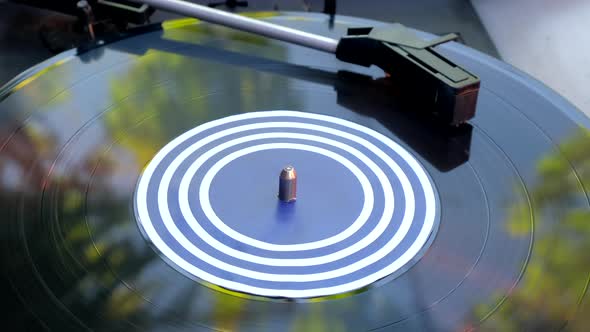 Stylus arm and needle lowered on black vinyl record on a DJ turntable ...