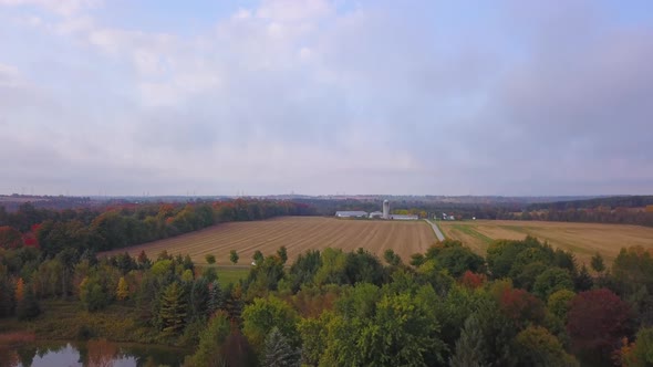 Aerial view flying over a barn roof to reveal picturesque farmland ...