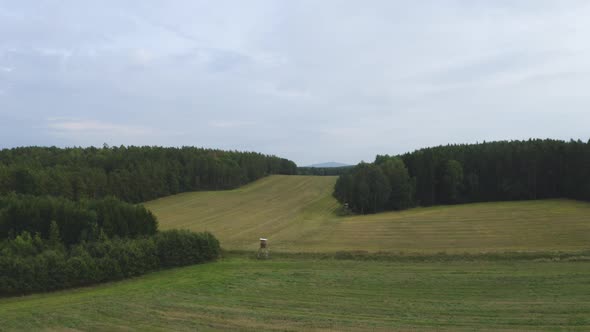 Two small simple wooden outposts standing between dense forests and a ...