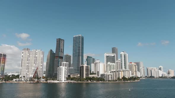 Wide aerial view of Brickell waterfront downtown Miami flying out over ...