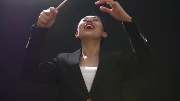 Asian Conductor Woman Holding A Baton And Showing Gesture Quickly In ...