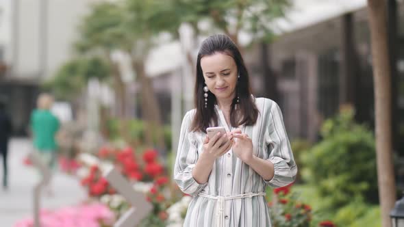 Portrait of a Woman in a Long Dress Texting on Smartphone in the City ...