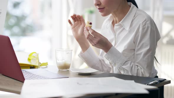 Unrecognizable Busy Young Woman Eating Lunch and Typing on Laptop ...