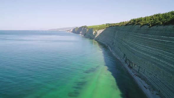 Aerial of High Steep Cliffs Covered with Pine Trees and Wild Pebble ...