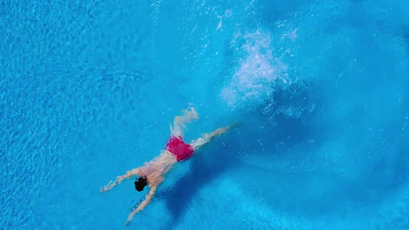 View From the Top As a Man Dives Into the Pool and Swims Under the ...