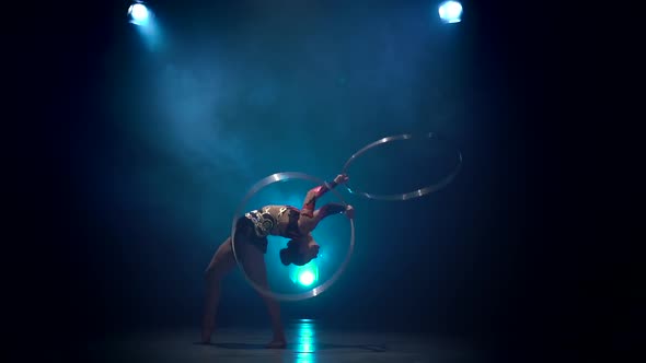 Acrobat Performs with Hoops. Blue Smoke Background. Slow Motion, Stock ...