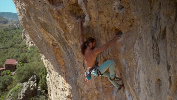 Young Powerful Athletic Man Rock Climber with Long Hair Climbing on ...