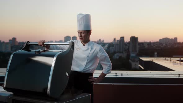 A professional Chef prepares a barbecue on the rooftop of a skyscraper ...