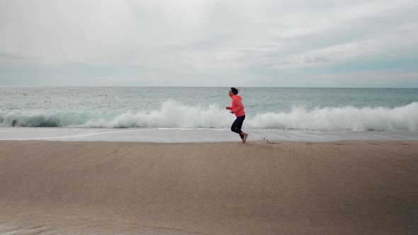 Woman running near ocean waves, Stock Footage | VideoHive