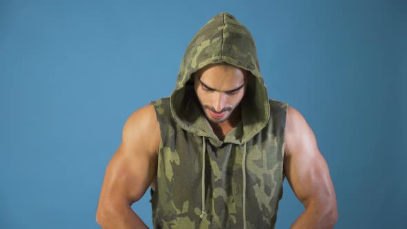 Bodybuilder in Camouflage Hoodie Flexing Biceps Muscles and Chests ...