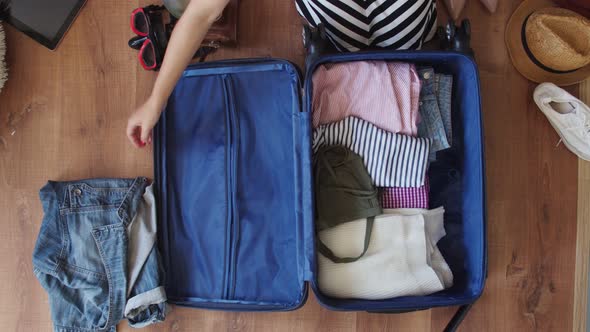 Timelapse of preparing a suitcase for vacation, top view. Women's hands ...