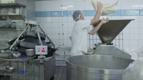 Bakery Production Line. A Bakery Worker Feeds the Dough Into an ...