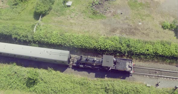 Overhead aerial view of a steam locomotive pulling carriages over a ...