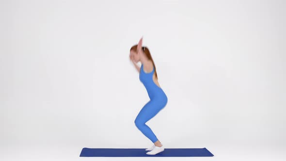 Sporty Young Female Making Burpee Exercise on Fitness Mat in Studio ...