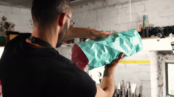 A male creator, sculptor, handyman creates a handmade art object ...