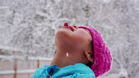 Girl catching snow flakes on tongue, Stock Footage | VideoHive