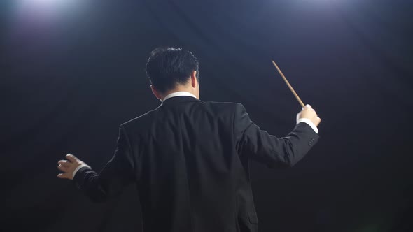 Back View Of Asian Conductor Man Holding A Baton And Showing Gesture In ...