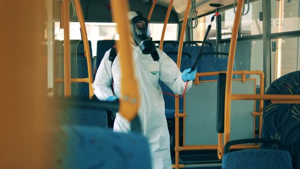 Specialist in a Protection Suit Is Sanitizing Bus Interior, Stock Footage