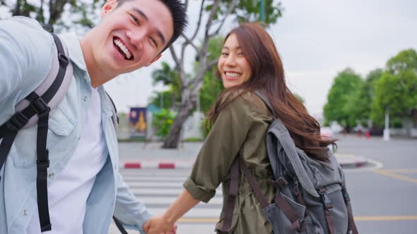 POV Asian couple backpacker use mobile phone take a video clip in city ...