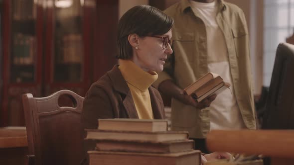 People Returning Books to Librarian in Public Library, Stock Footage