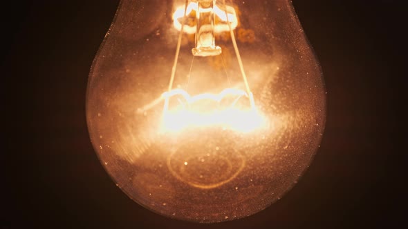 Light Bulb Slowly Turned On and Off on Black Background, Stock Footage