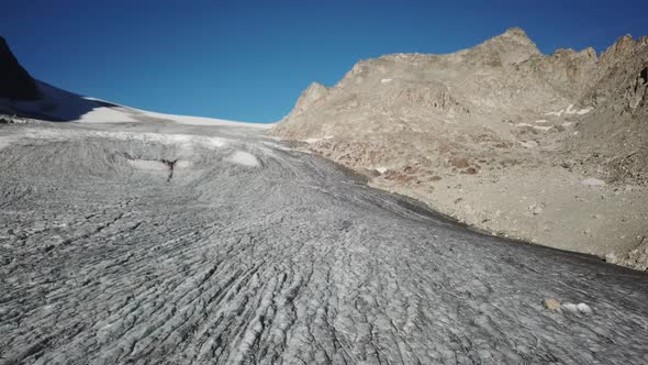 large glacier with ridges and crevasses creating a plain in swiss high ...