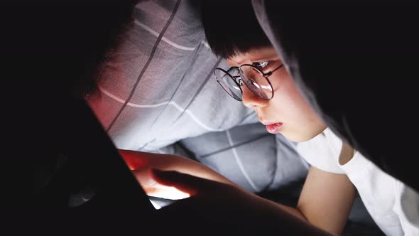 boy playing tablet pc in bed at night, Stock Footage | VideoHive