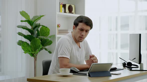 young man in casual clothes is stressed out of working from home on a ...