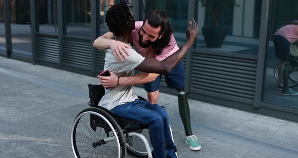 Multiethnic friends with disability greeting each other in the city ...