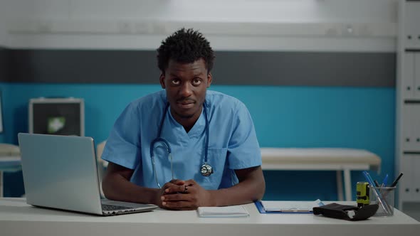Close Up of Black Medical Assistant Smiling Sitting at Desk, Stock Footage