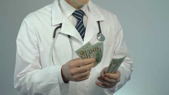 Male Doctor Counting Money, Paid Health Care Services at Private Clinic ...
