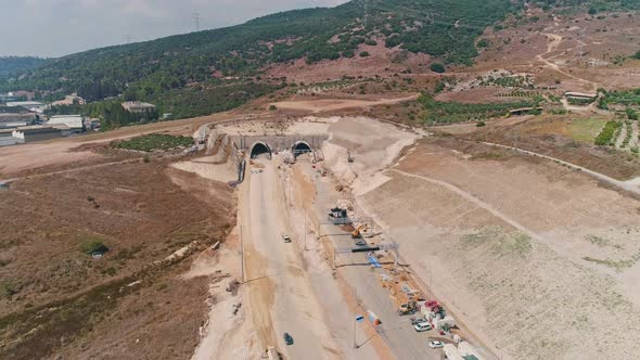 Aerial footage of large highway construction project with tunnels and ...