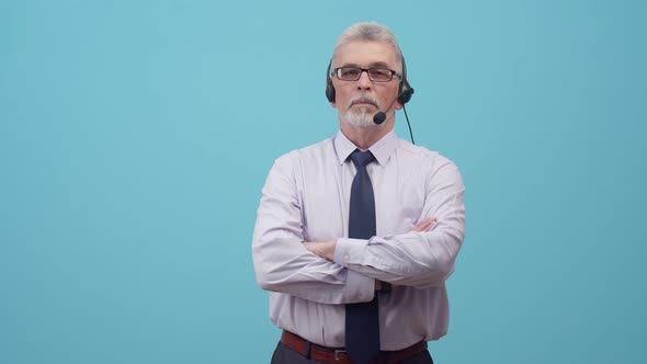 Man call operator in headset crosses arms, on studio the blue ...