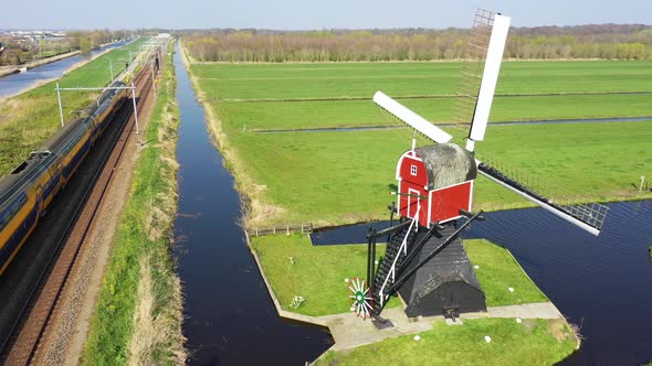Aerial View of High Speed Train Passing By Traditional Dutch Windmill ...