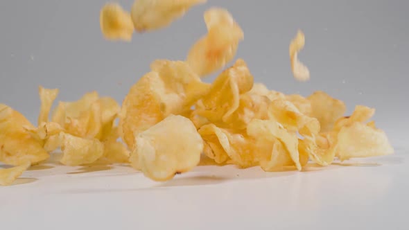 Potato Chips falling onto a white surface in slow motion, Stock Footage