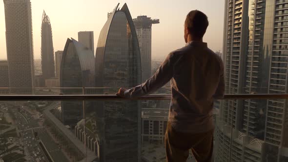 Young Man Standing on Balcony Overlooking Metropolis Real Estate ...