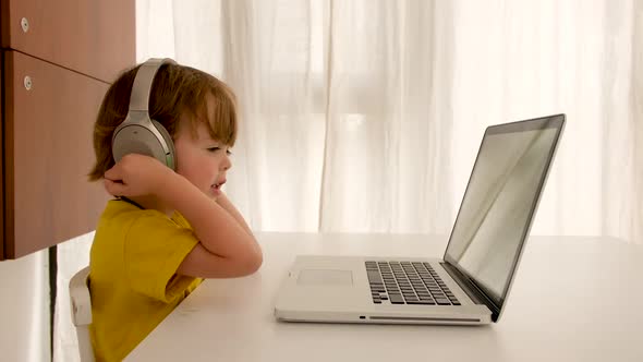 Child Listens To Music on Headphones in Front of Laptop, Stock Footage