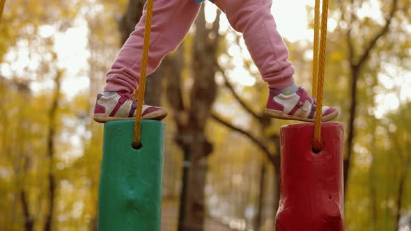 Little Child Make Steps and Balancing on Swinging Wooden Stump in Rope ...