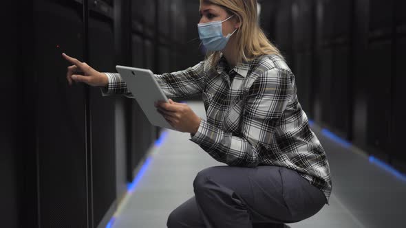 Female informatic engineer working inside server room database while ...