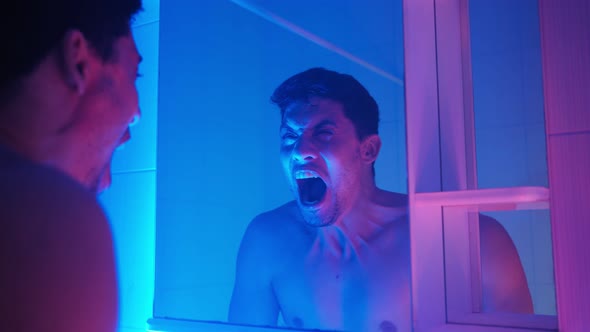 Angry Man Yells Into the Mirror Above the Washbasin in Neon Lighting ...