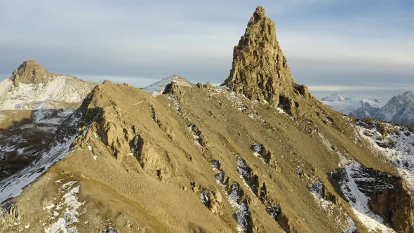 Aerial shot passing close to terrain and climbing above rocky summit ...