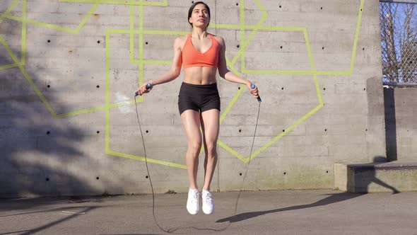 Young Latina Woman using jump rope by concrete wall, Wide Shot, Stock ...