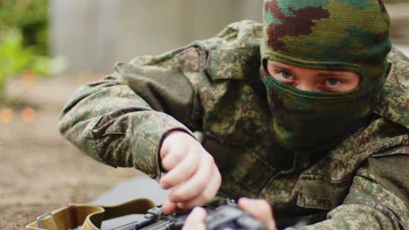 Closeup of a Masked Soldier Preparing to Fire and Pointing the Machine ...