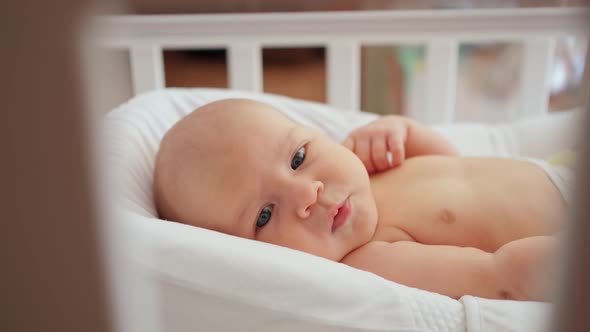 Cute Little Newborn Baby Lies in a White Crib in a Newborn Cocoon and ...
