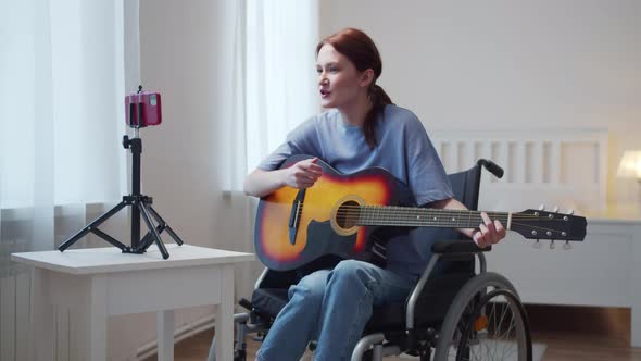 A Disabled Lady is Playing the Guitar and Singing Songs, Stock Footage