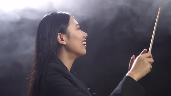 Asian Conductor Woman Holding A Baton Closing Her Eyes And Showing ...
