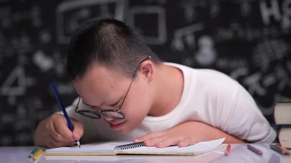A Boy with downs syndrome studying writing English alphabet., Stock Footage