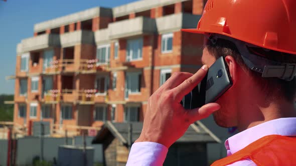 Construction Worker Phones with the Smartphone in Front of Building ...