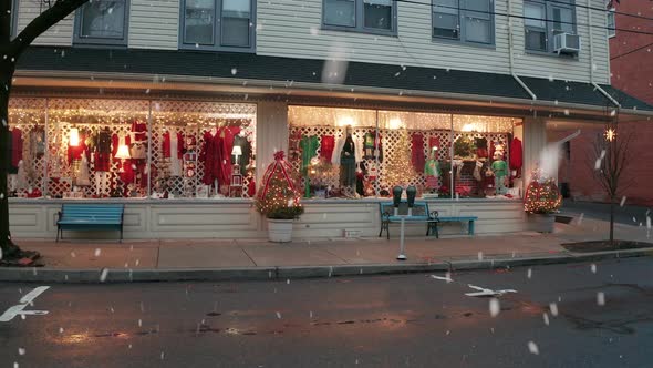Winter window shopping. Snow falling. Storefront decorated for ...