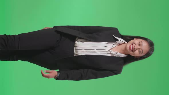 A Smiling Asian Business Woman Walking Through Green Screen In The ...